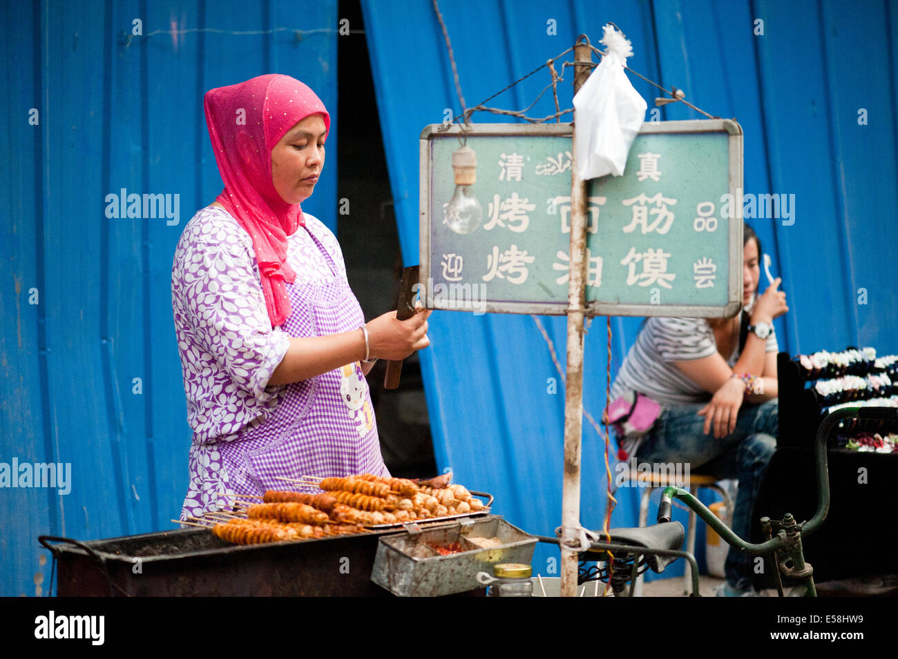 Hui muslim woman prepares street food at famous Muslim Street in Xian ...