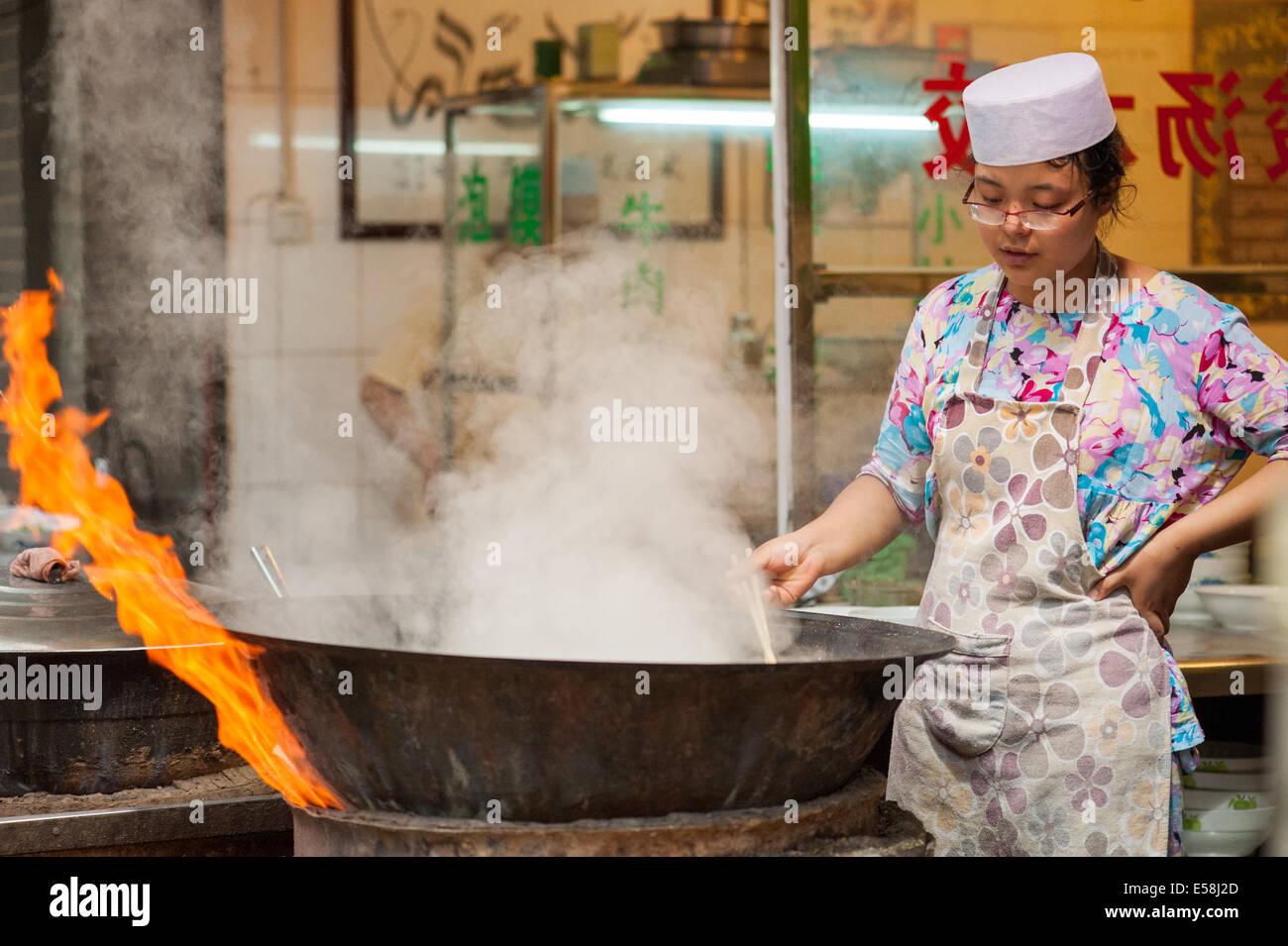 Hui muslim woman prepares street food at famous Muslim Street in Xian ...
