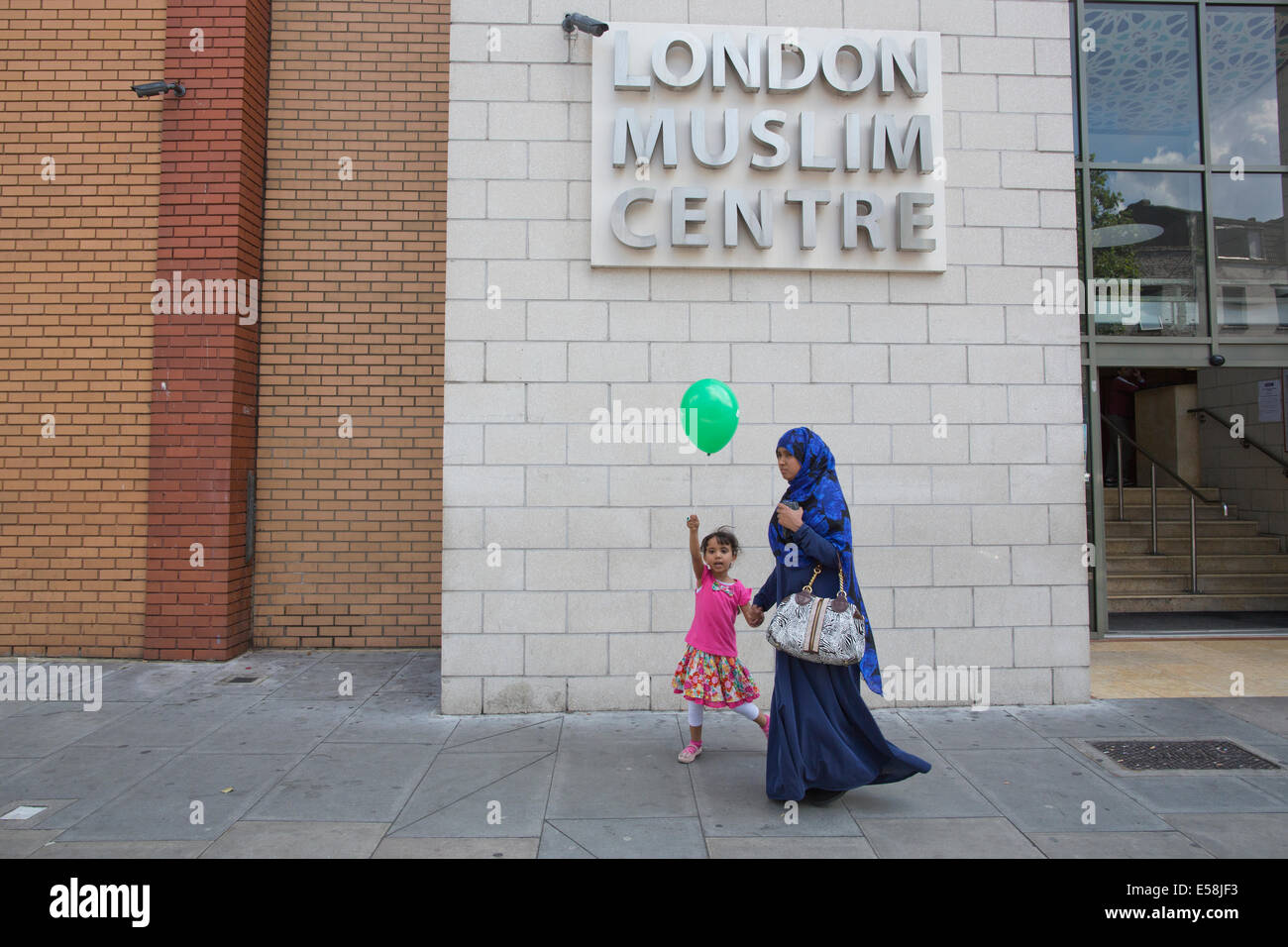 Islamic woman and child pass by the London Muslim Centre, East London ...