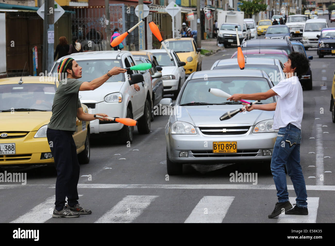 Two students joggling in the streets of Bogota to entertain car drivers ...