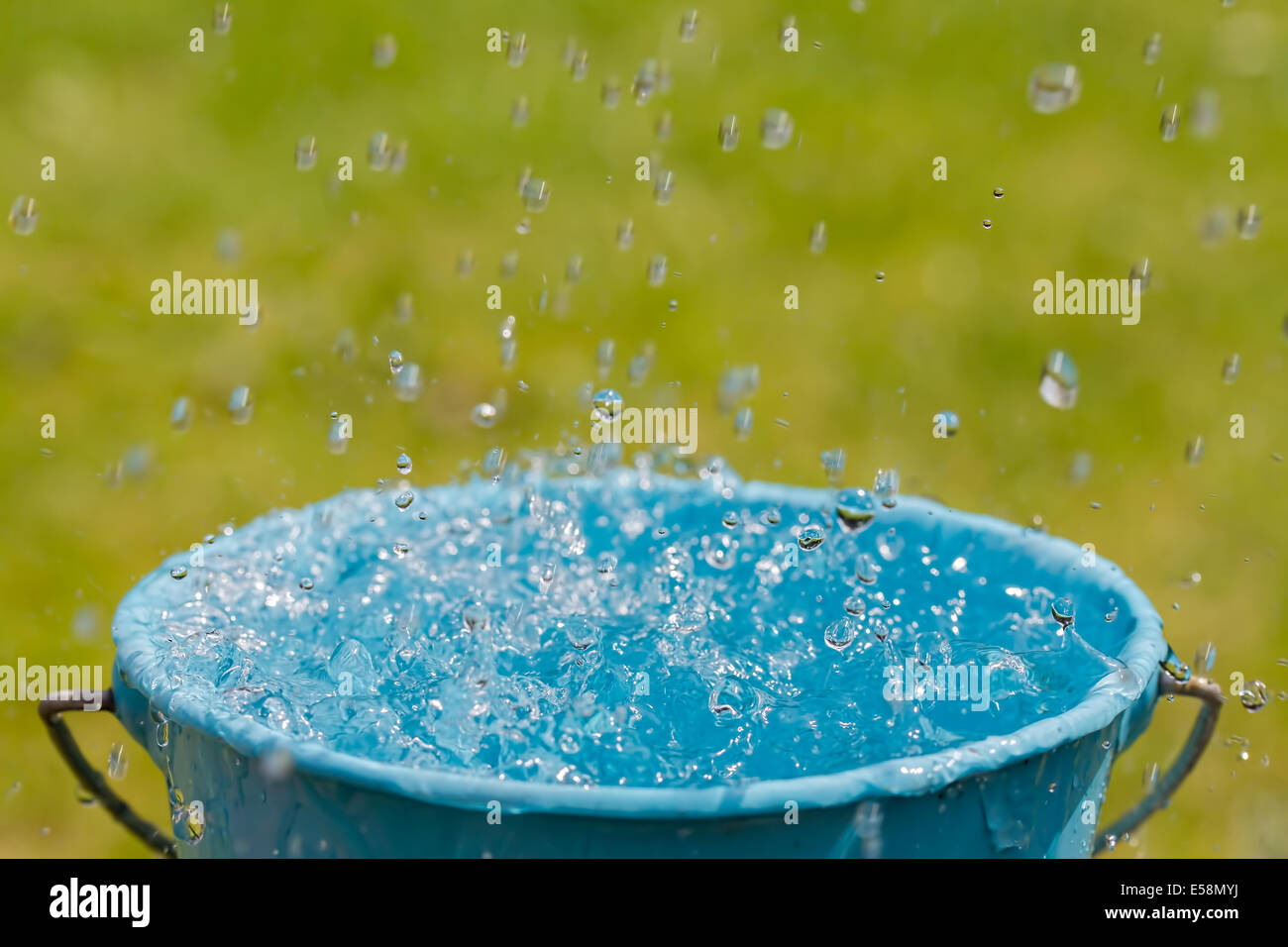 Rain falling into full bucket of water Stock Photo - Alamy