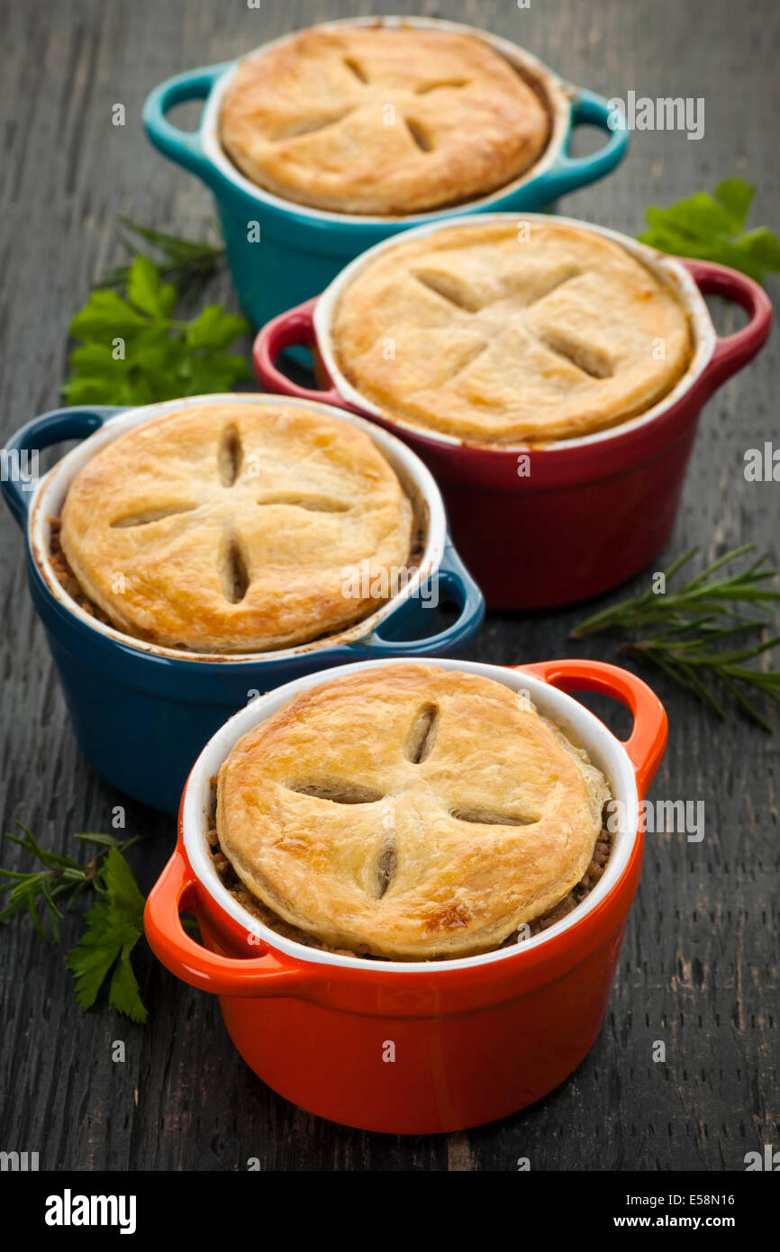 Four homemade gourmet meat pies on wooden background Stock Photo - Alamy