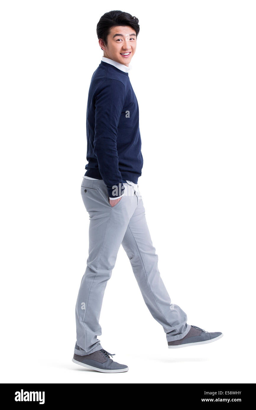 Man walking hands in pockets Cut Out Stock Images & Pictures - Alamy