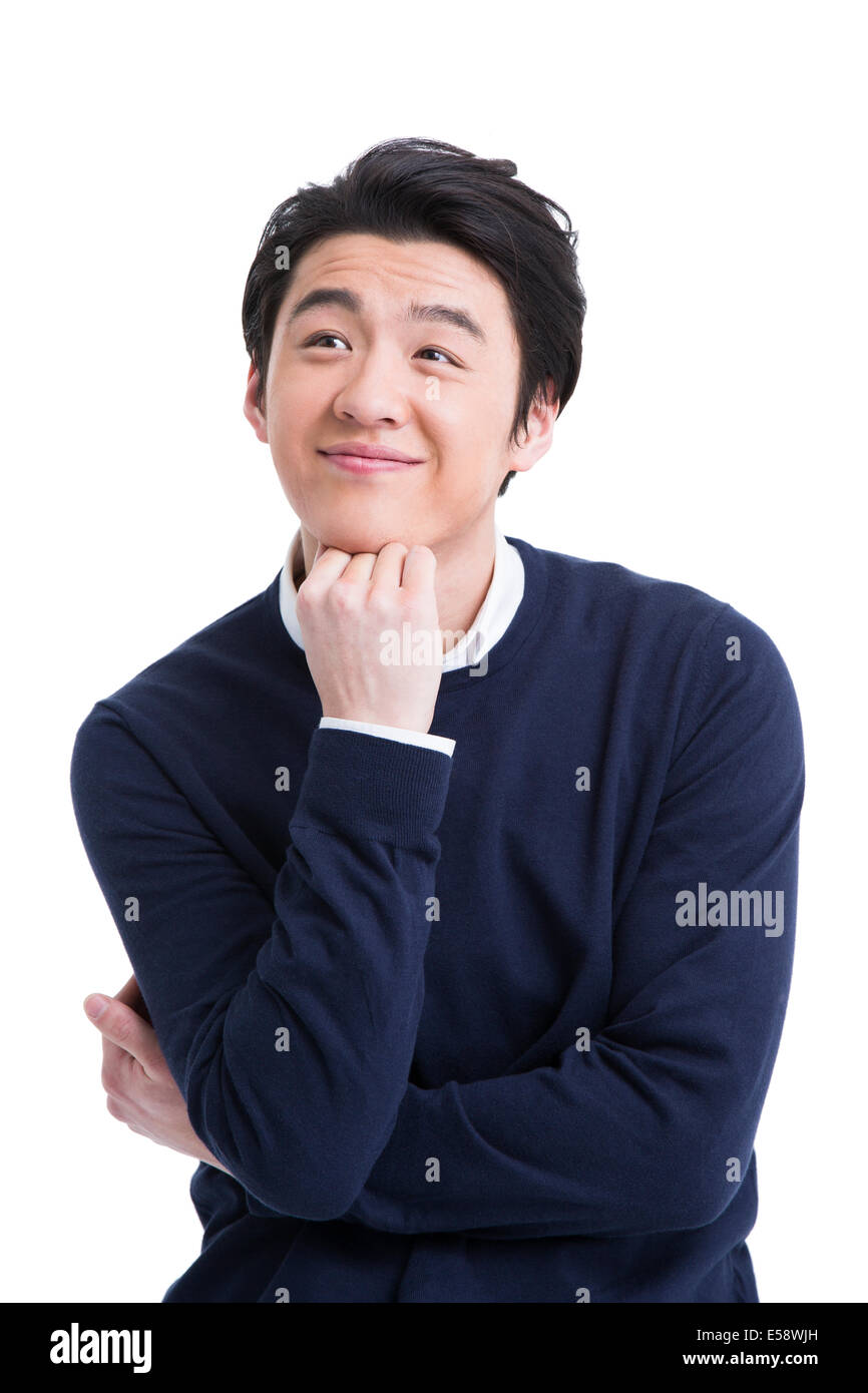 Young man with hand on chin Stock Photo - Alamy