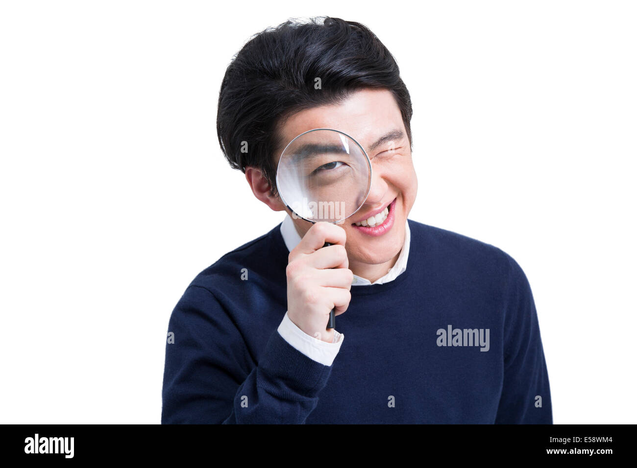 Young man with magnifying glass Stock Photo - Alamy