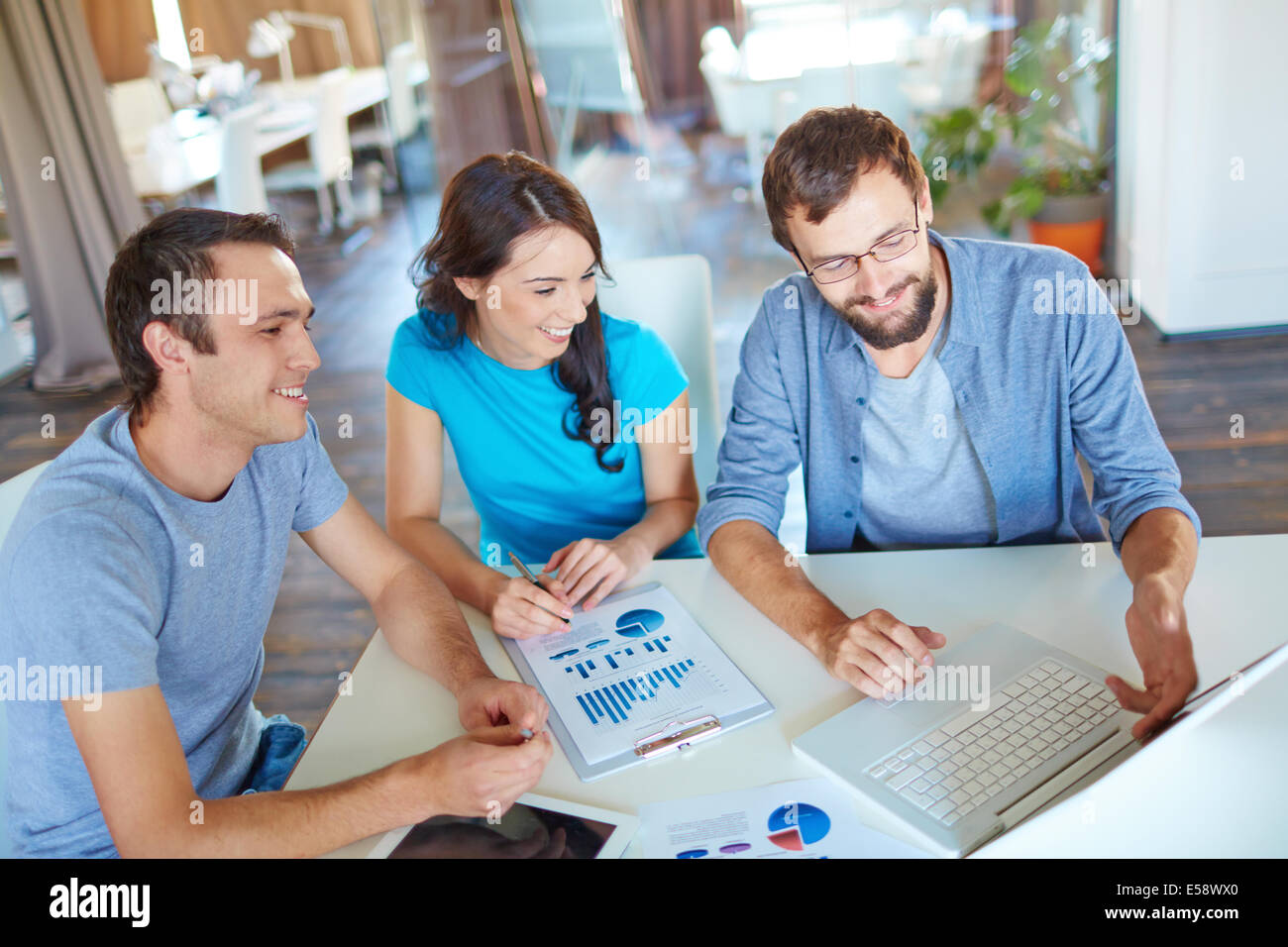 Group of three successful business partners in casual discussing ...