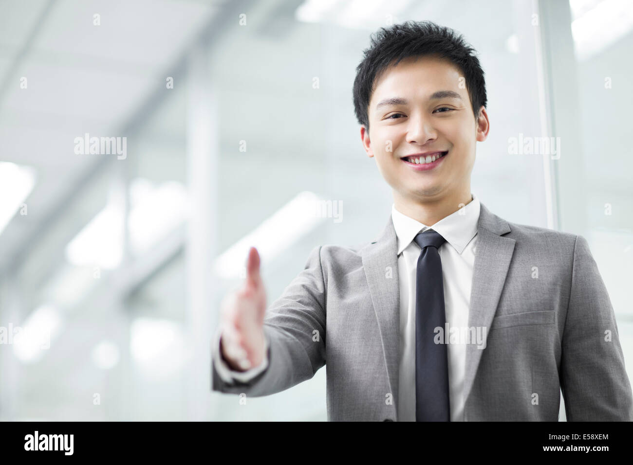 Young businessman extending hand for handshake Stock Photo - Alamy