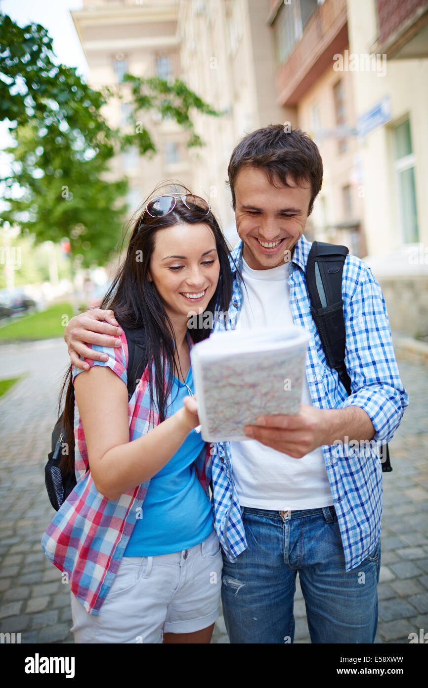 Couple of travelers looking at map during their journey Stock Photo - Alamy
