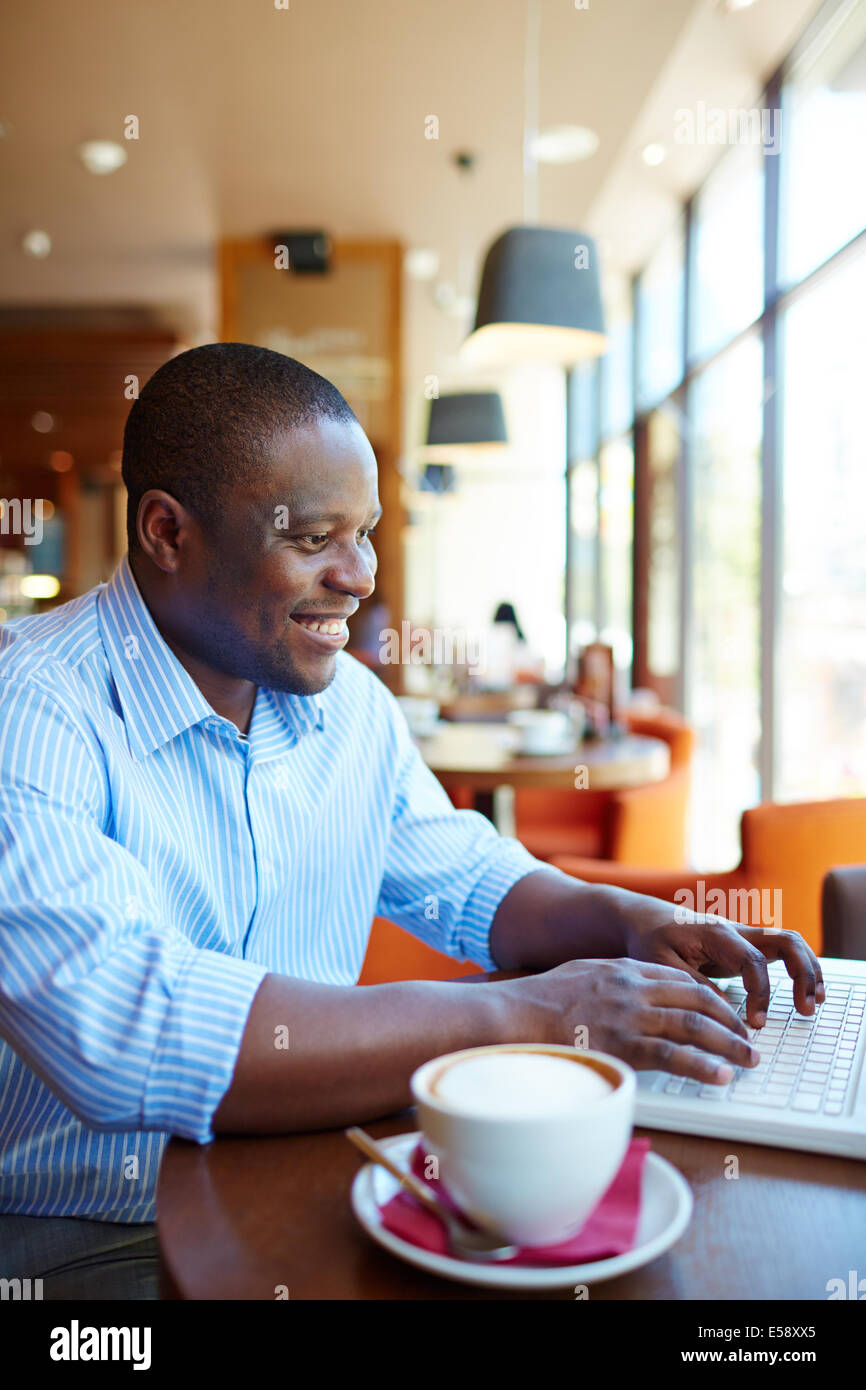 Image of young man typing on laptop in cafe Stock Photo - Alamy