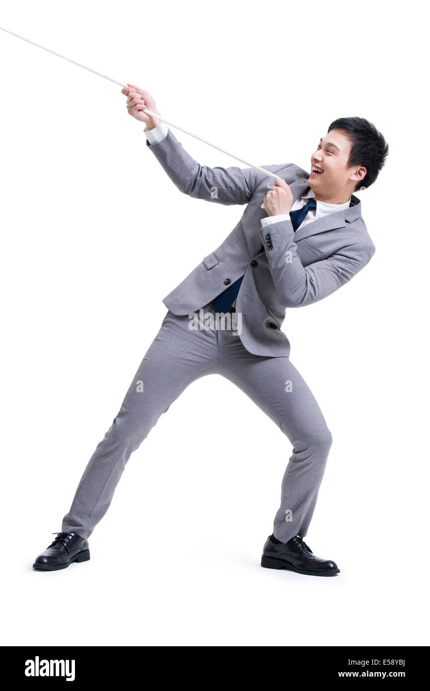 Excited businessman pulling rope Stock Photo - Alamy