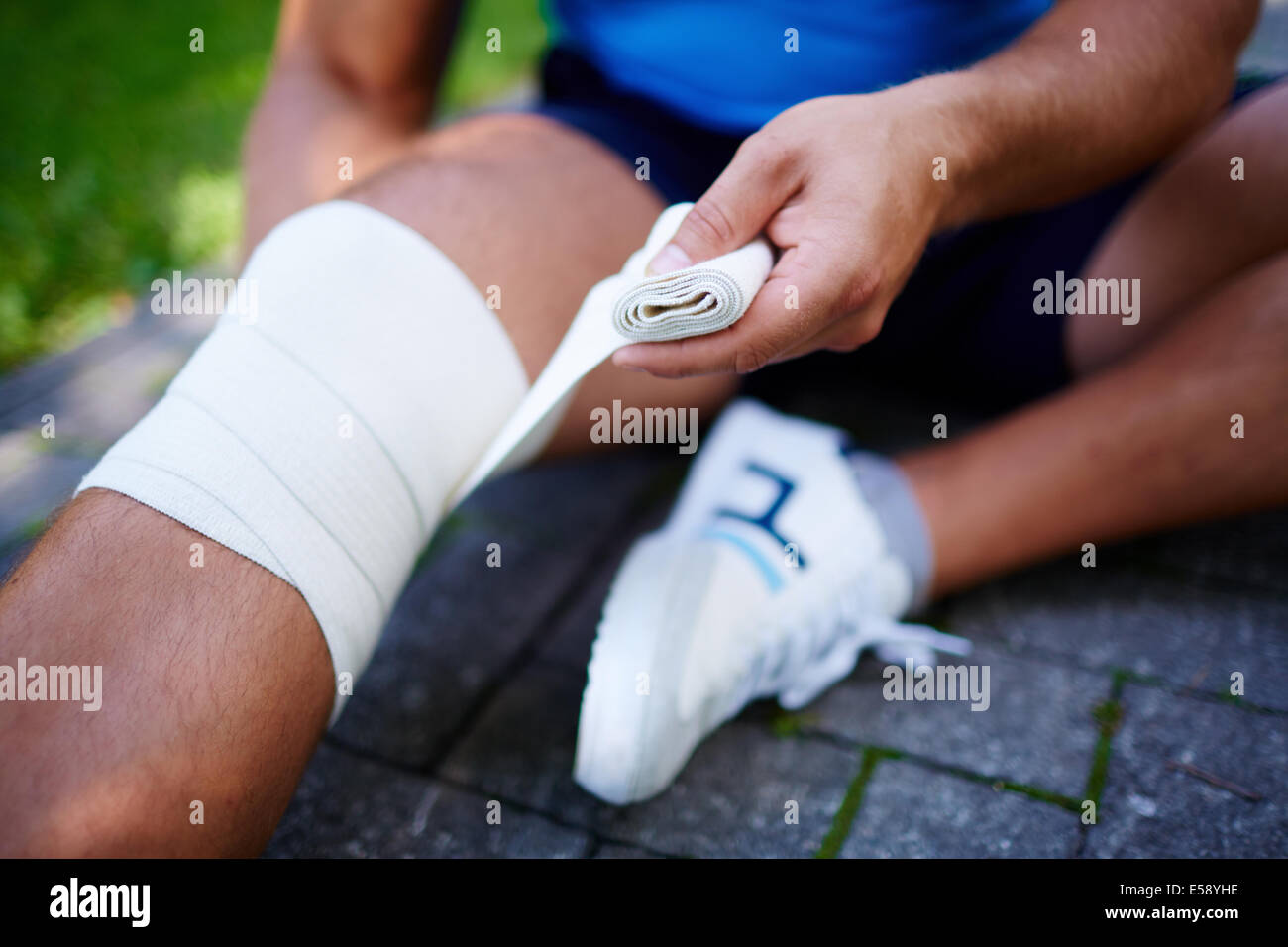 Close-up of male bandaging his leg Stock Photo - Alamy