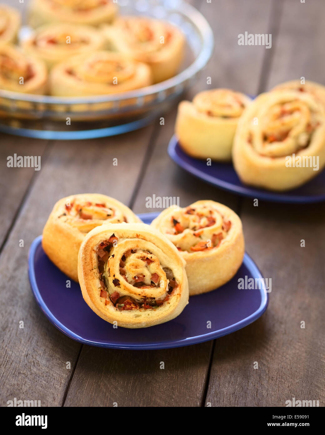 Freshly baked homemade rolls filled with tomato, ham and herbs on blue ...