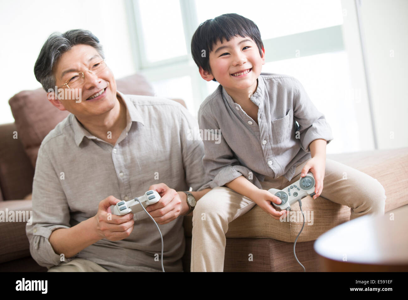 Cheerful grandfather and grandson playing video game Stock Photo - Alamy