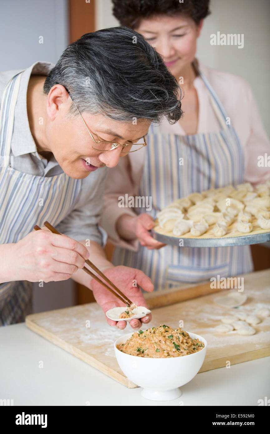 Happy senior couple making dumplings Stock Photo - Alamy