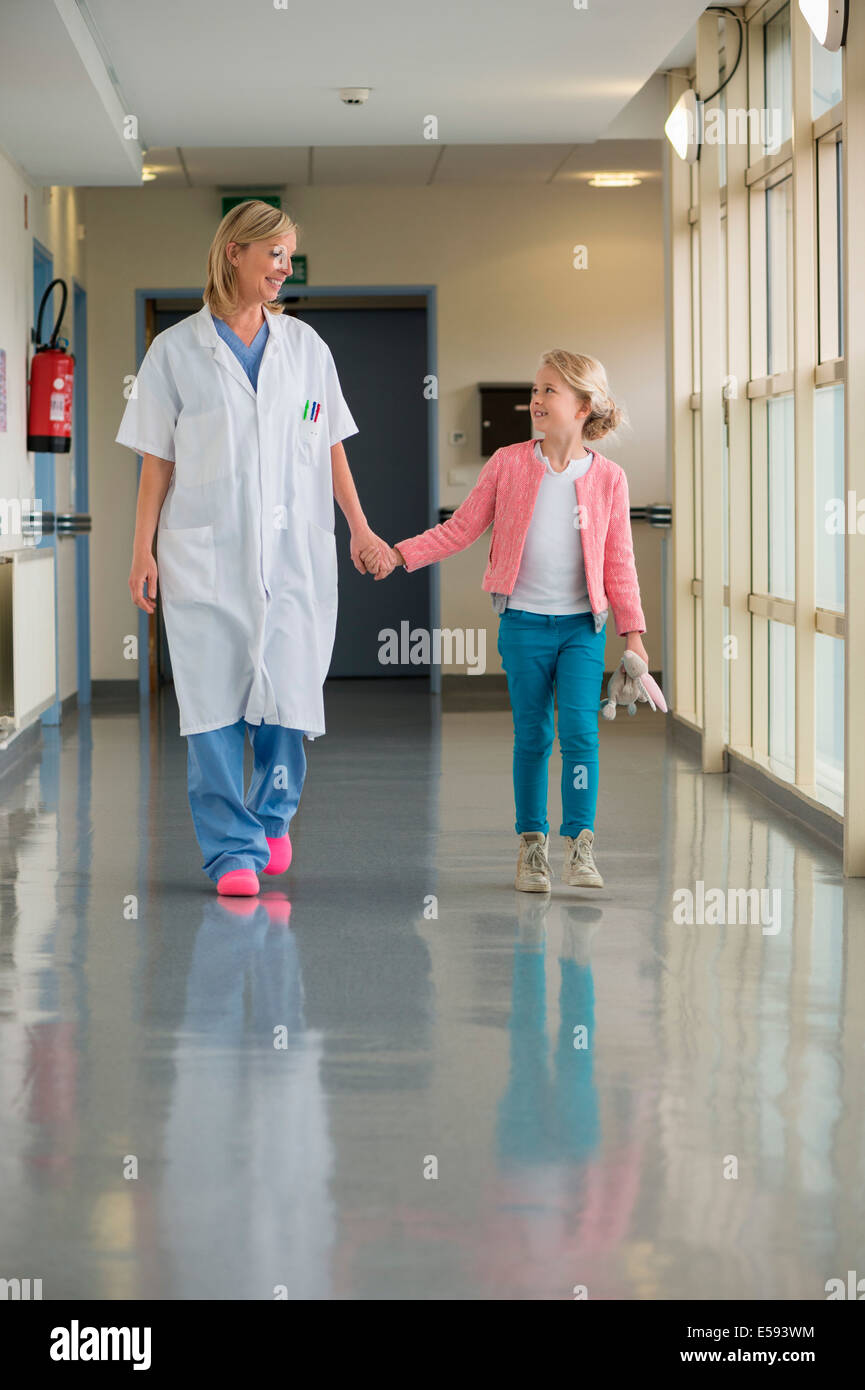 Female doctor walking with a girl in the corridor of a hospital Stock ...