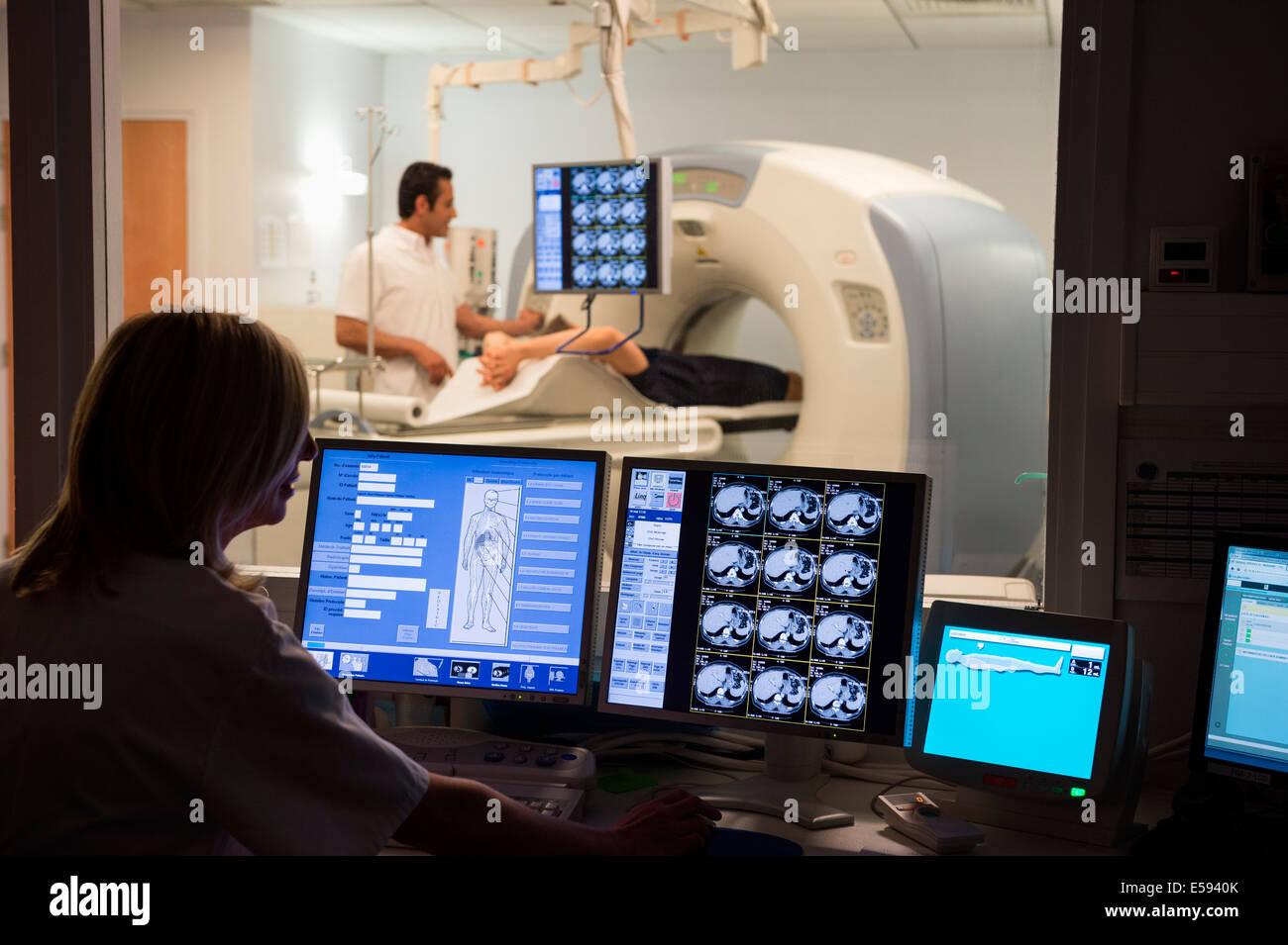 Female doctor examining scan on computer with patient on MRI scanner in ...