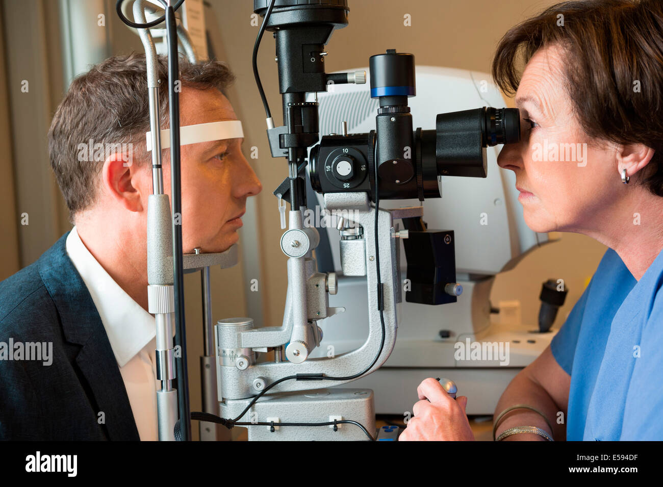 Female optometrist examining man's eyes Stock Photo - Alamy