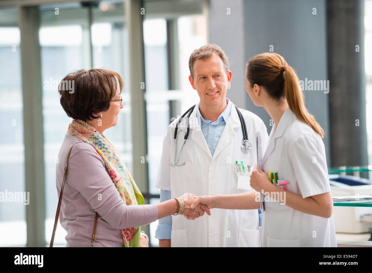 Doctor shaking hands with his patient at hospital reception Stock Photo ...