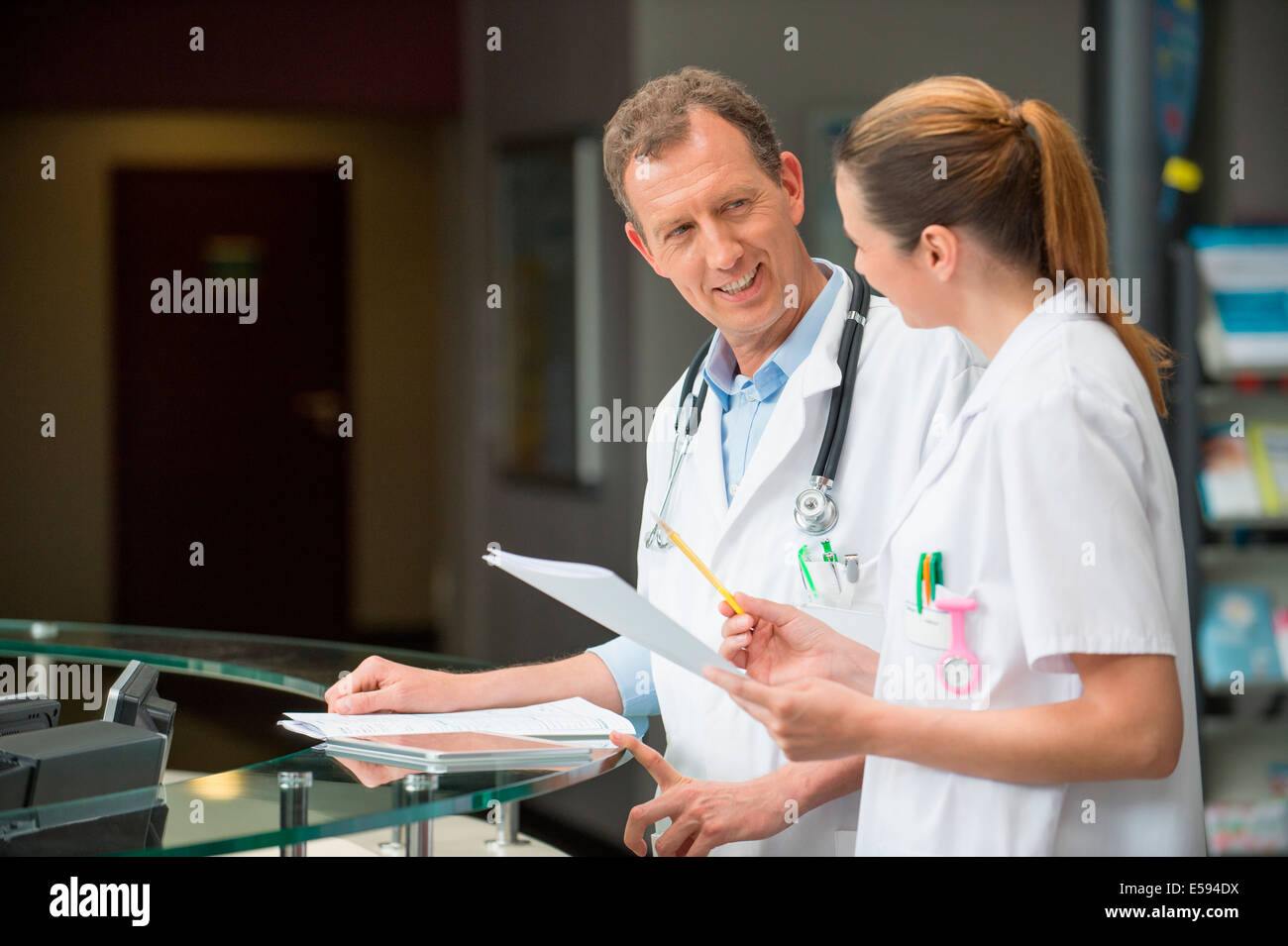 Two doctors discussing at hospital reception desk Stock Photo - Alamy Two doctors discussing at hospital reception desk Stock Photo - Alamy