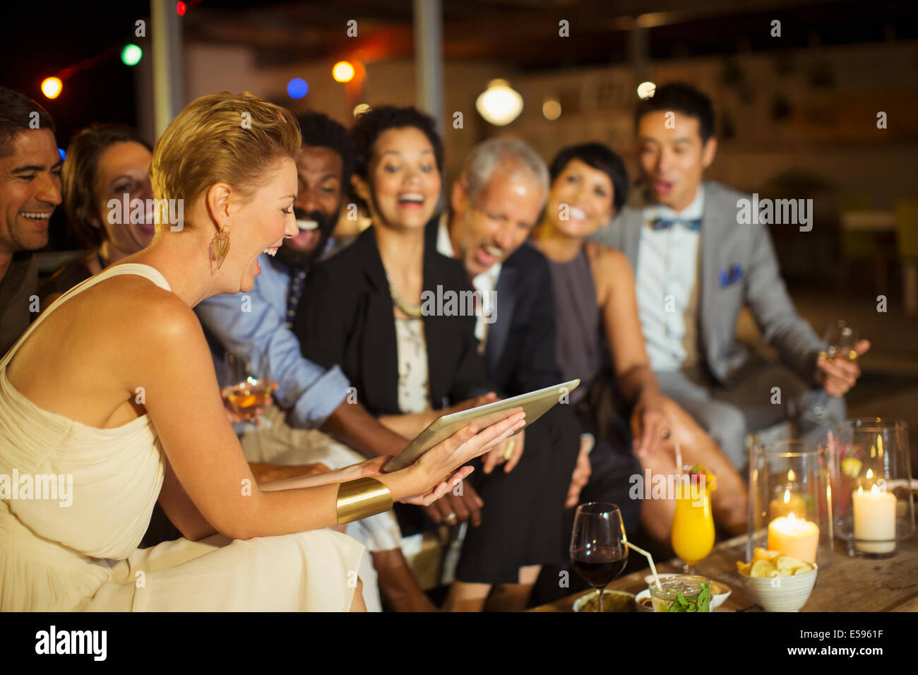 Friends using digital tablet at party Stock Photo - Alamy