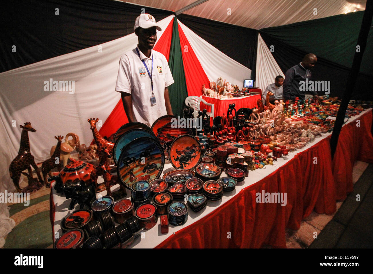 Curator George Morara of Tabaka Youth Group stands at his artwork ...