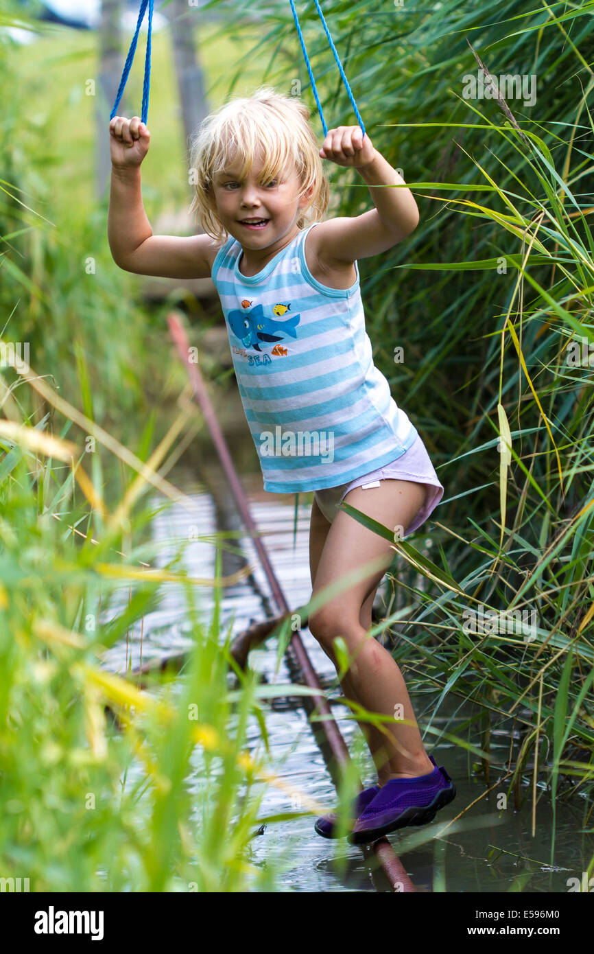 Little girl balancing on tightrope at climbing crag Stock Photo - Alamy