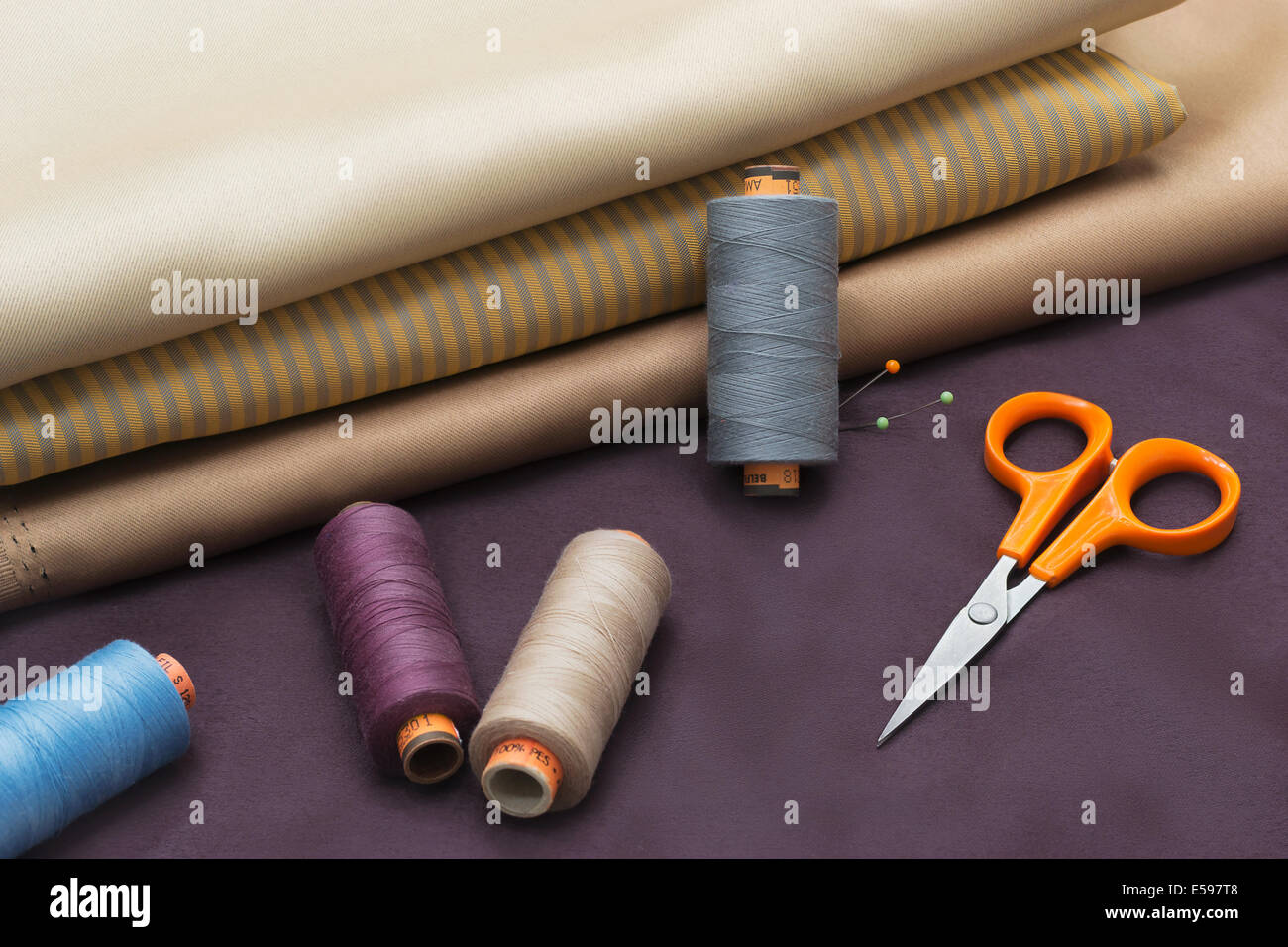 Different kind of fabric and tailors tools - thread spools, pin ...