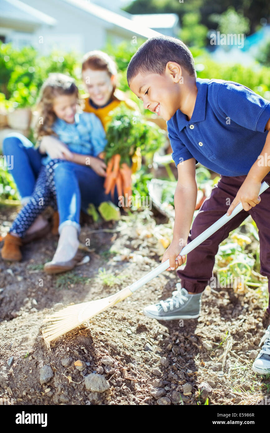 Boy turning over soil in garden Stock Photo - Alamy