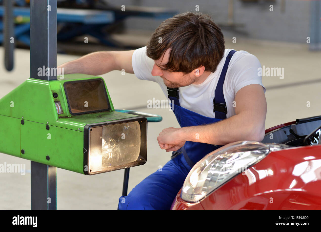 Car mechanic adjusting headlight Stock Photo - Alamy