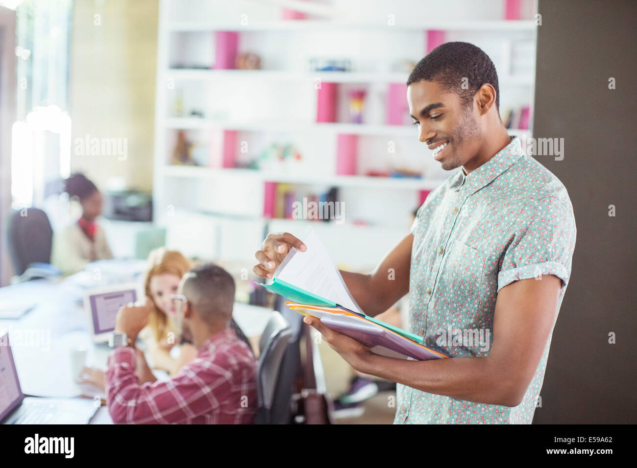 Man reading folders in office Stock Photo - Alamy