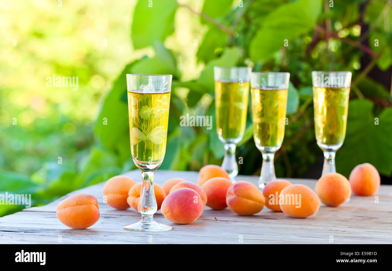 Apricot liquor and fruits on wooden table Stock Photo - Alamy