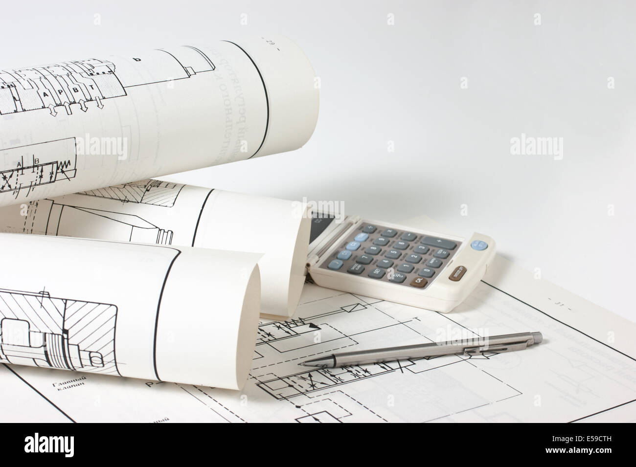 rolled technical drawings and a calculator Stock Photo - Alamy