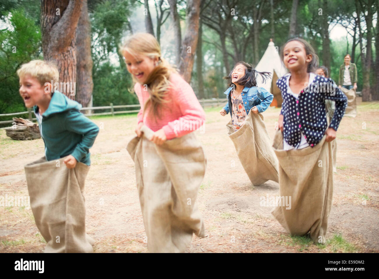 Children having sack race in field Stock Photo - Alamy