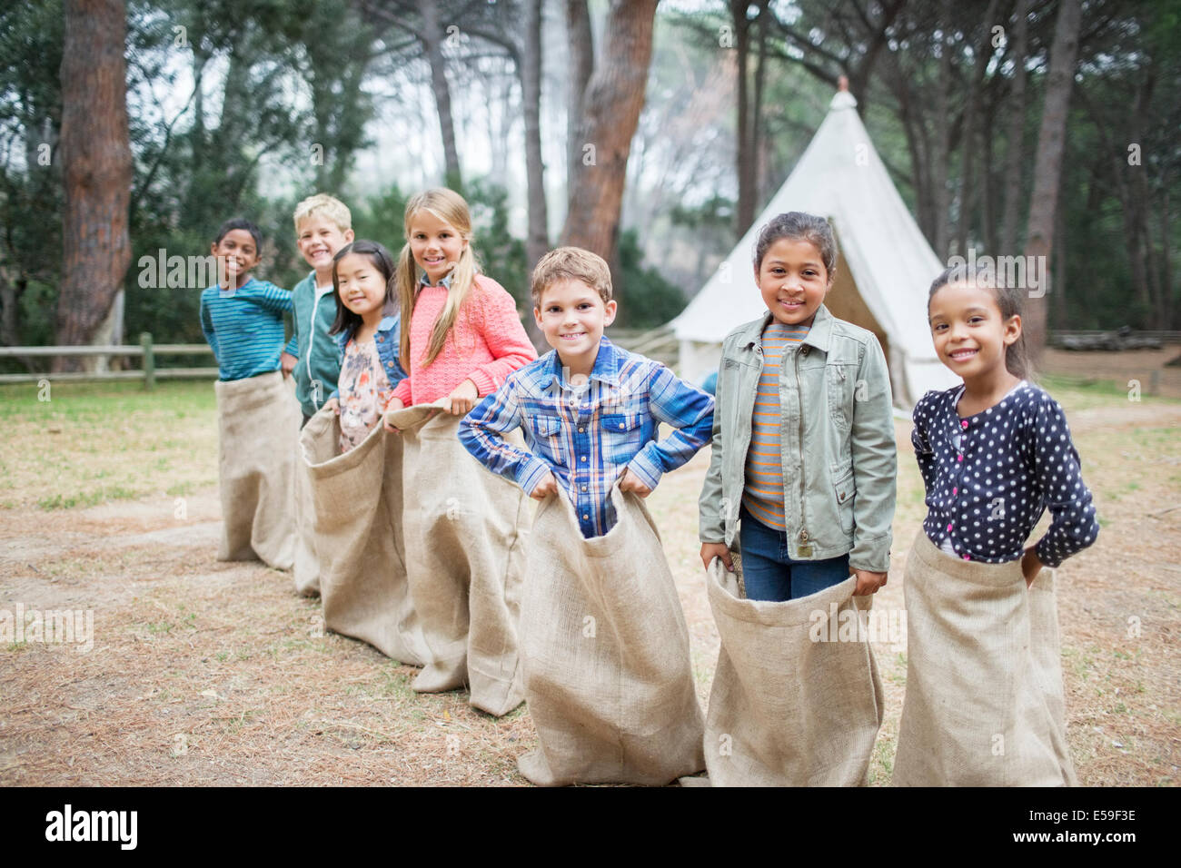 Children smiling at start of sack race Stock Photo - Alamy