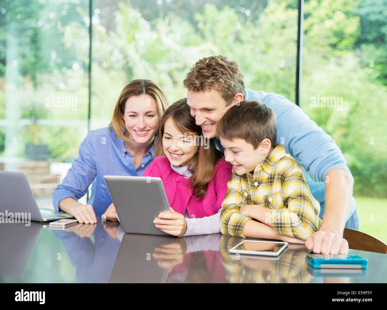Family using digital tablet together Stock Photo - Alamy
