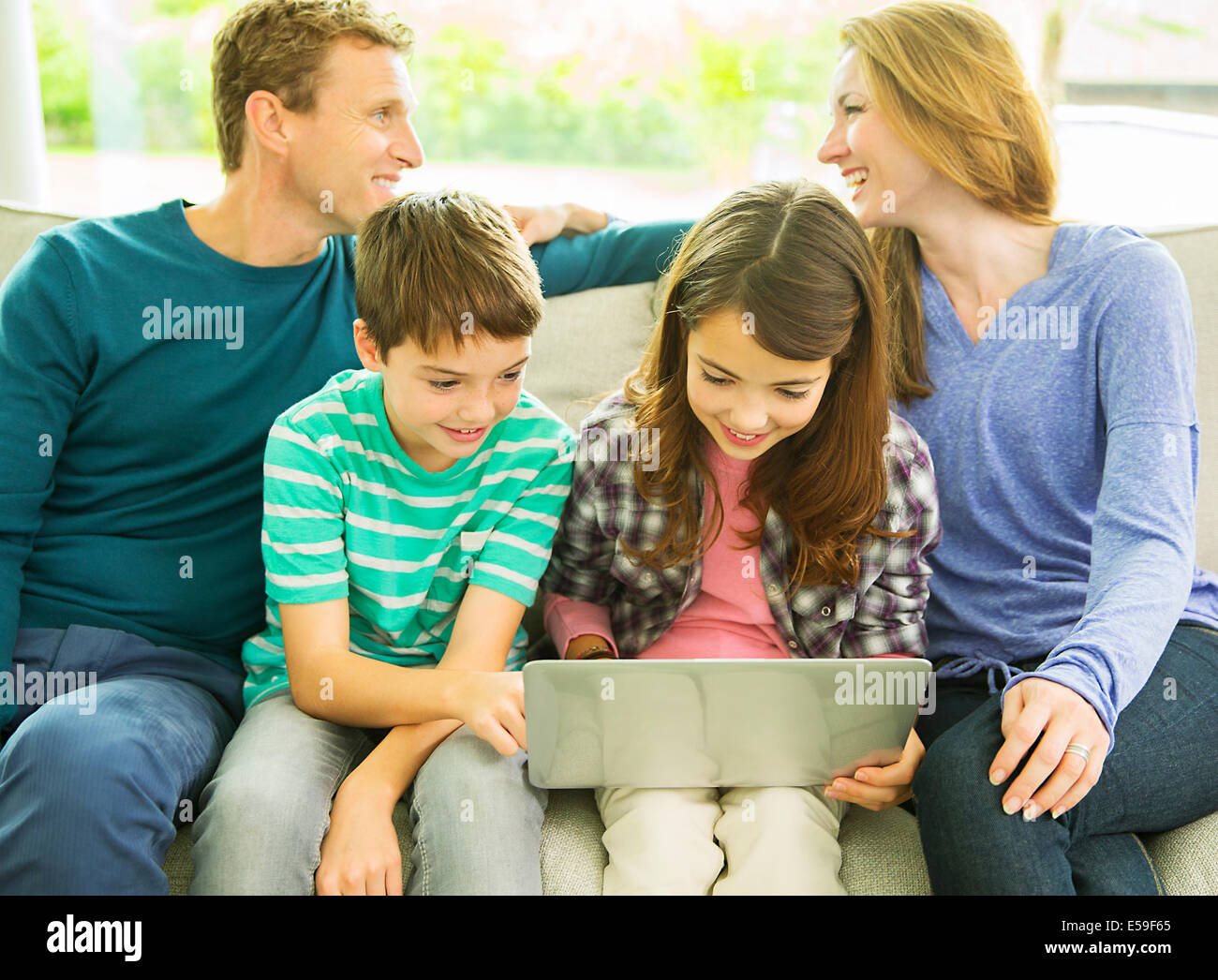 Family relaxing together on sofa Stock Photo - Alamy