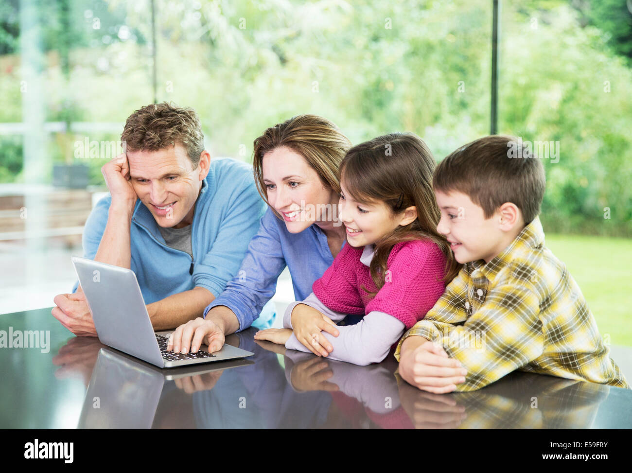 Family using laptop together Stock Photo - Alamy