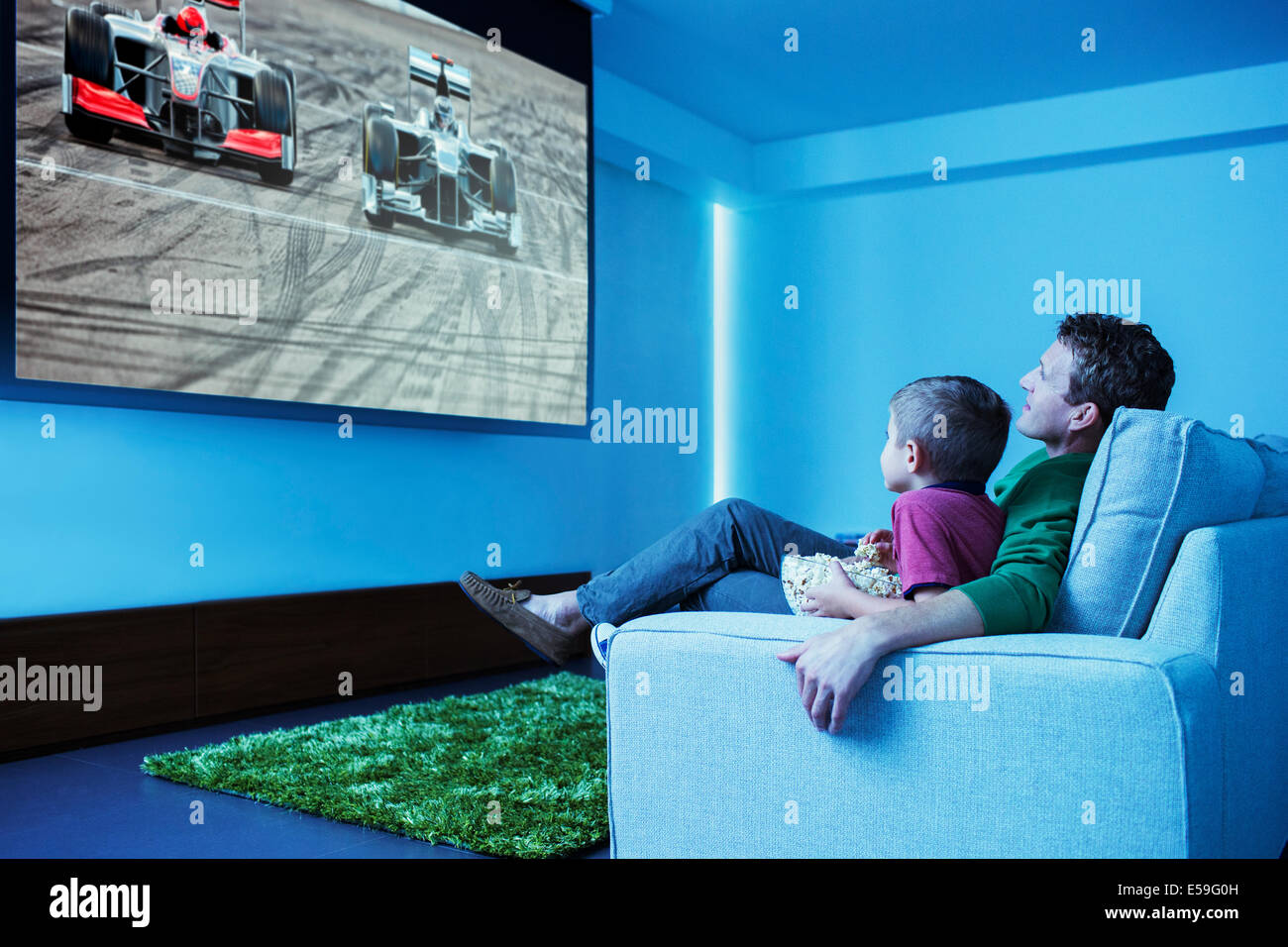 Father and son watching television in living room Stock Photo - Alamy