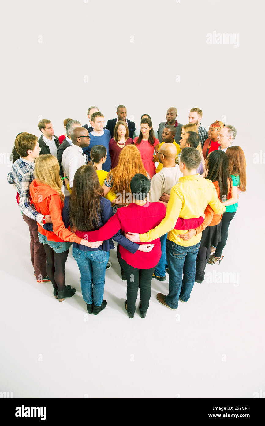 Diverse group forming huddle Stock Photo - Alamy