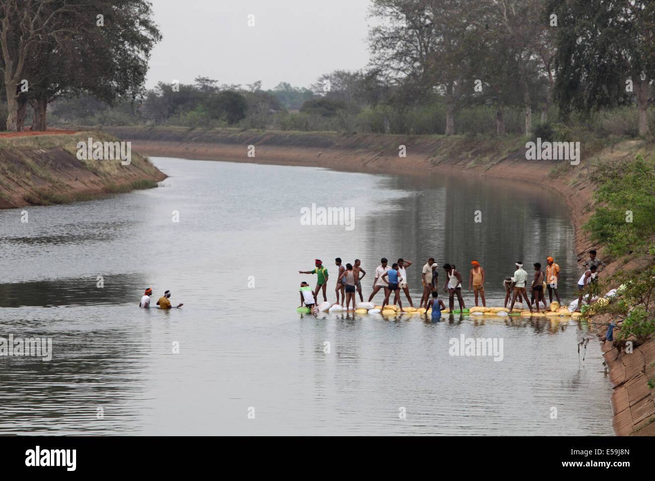 Gond men constructing a small bund in the canal, Bhata Village ...