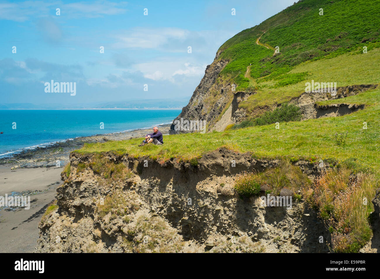 A walker takes a break on the Wales Coast Path between Borth and ...
