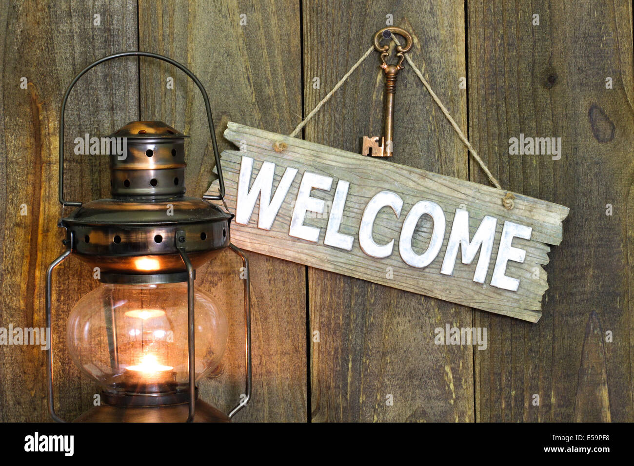 Welcome sign with bronze skeleton key hanging on wooden fence by ...