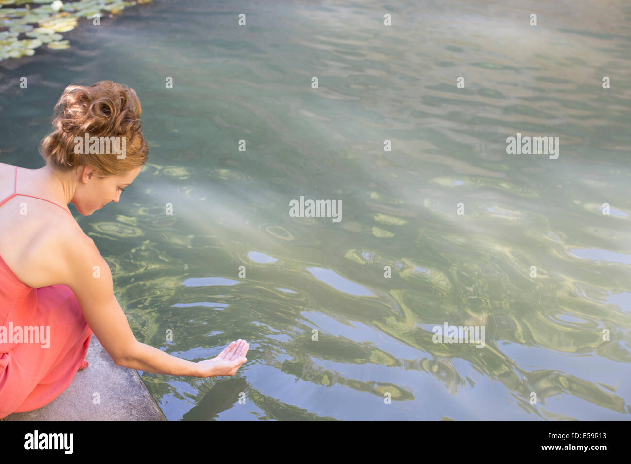Woman dipping her hand in pool Stock Photo - Alamy