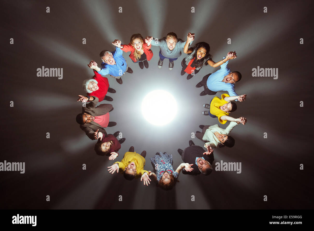 Diverse crowd around bright light Stock Photo - Alamy