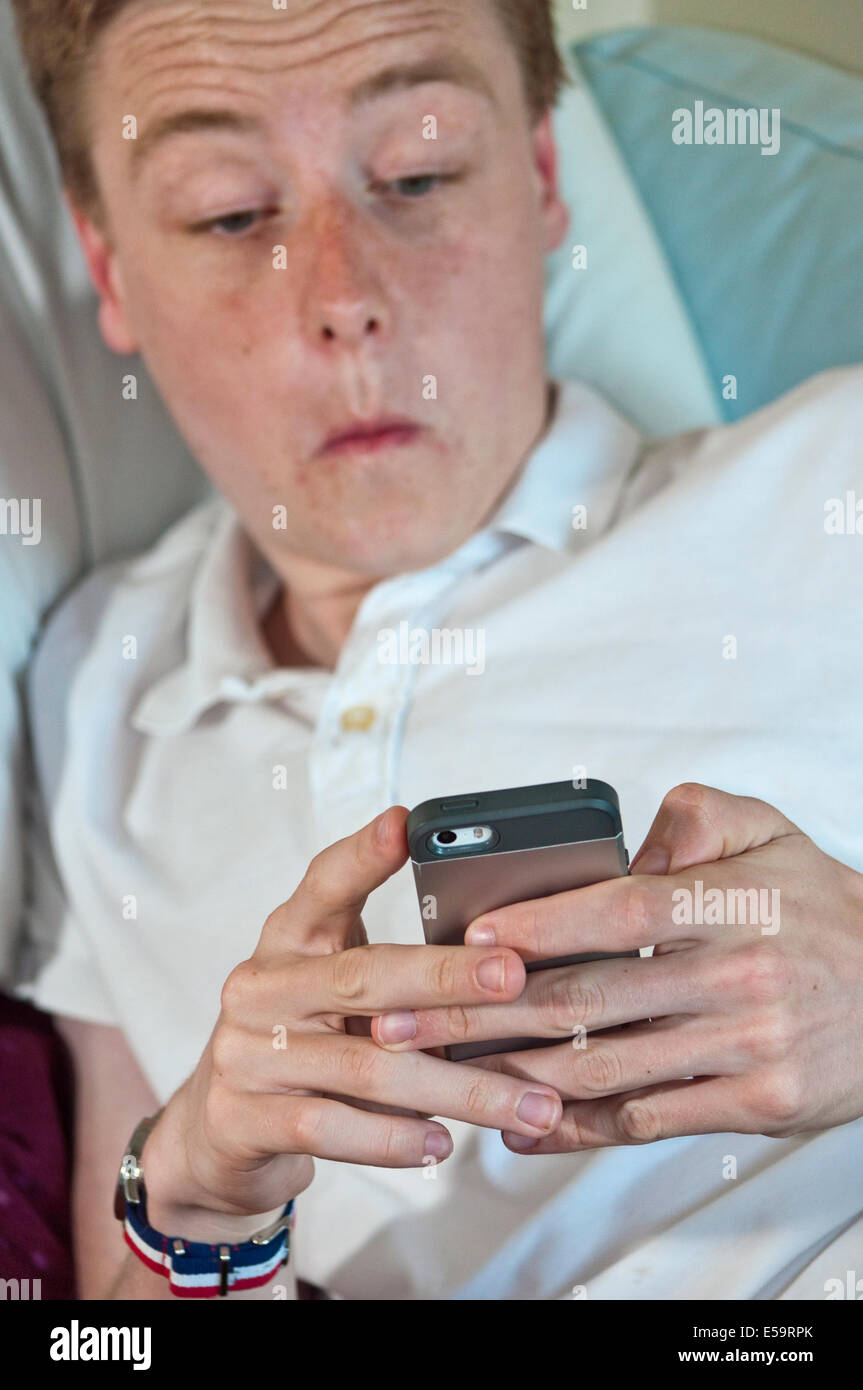 Male youth young man reading laughing at text message tweet Facebook on ...