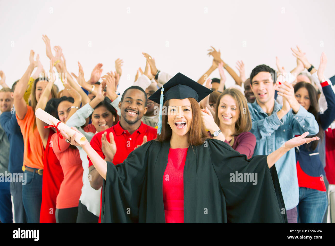 Crowd cheering behind confident graduate Stock Photo - Alamy
