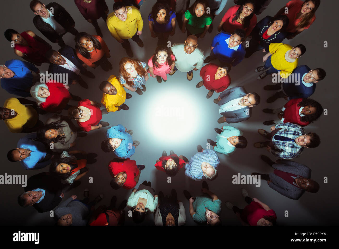 Portrait of confident business people around bright light Stock Photo ...