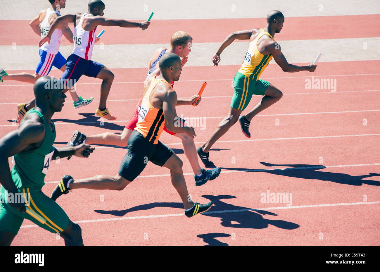 Relay runners racing on track Stock Photo - Alamy