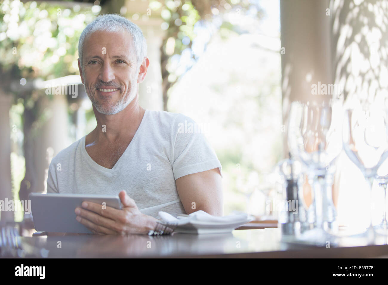 Man using digital tablet at table Stock Photo - Alamy