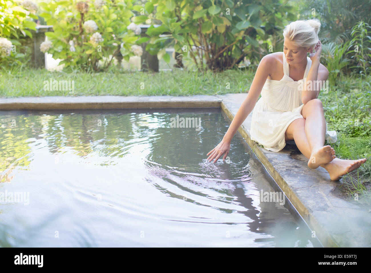 Woman relaxing by pool Stock Photo - Alamy